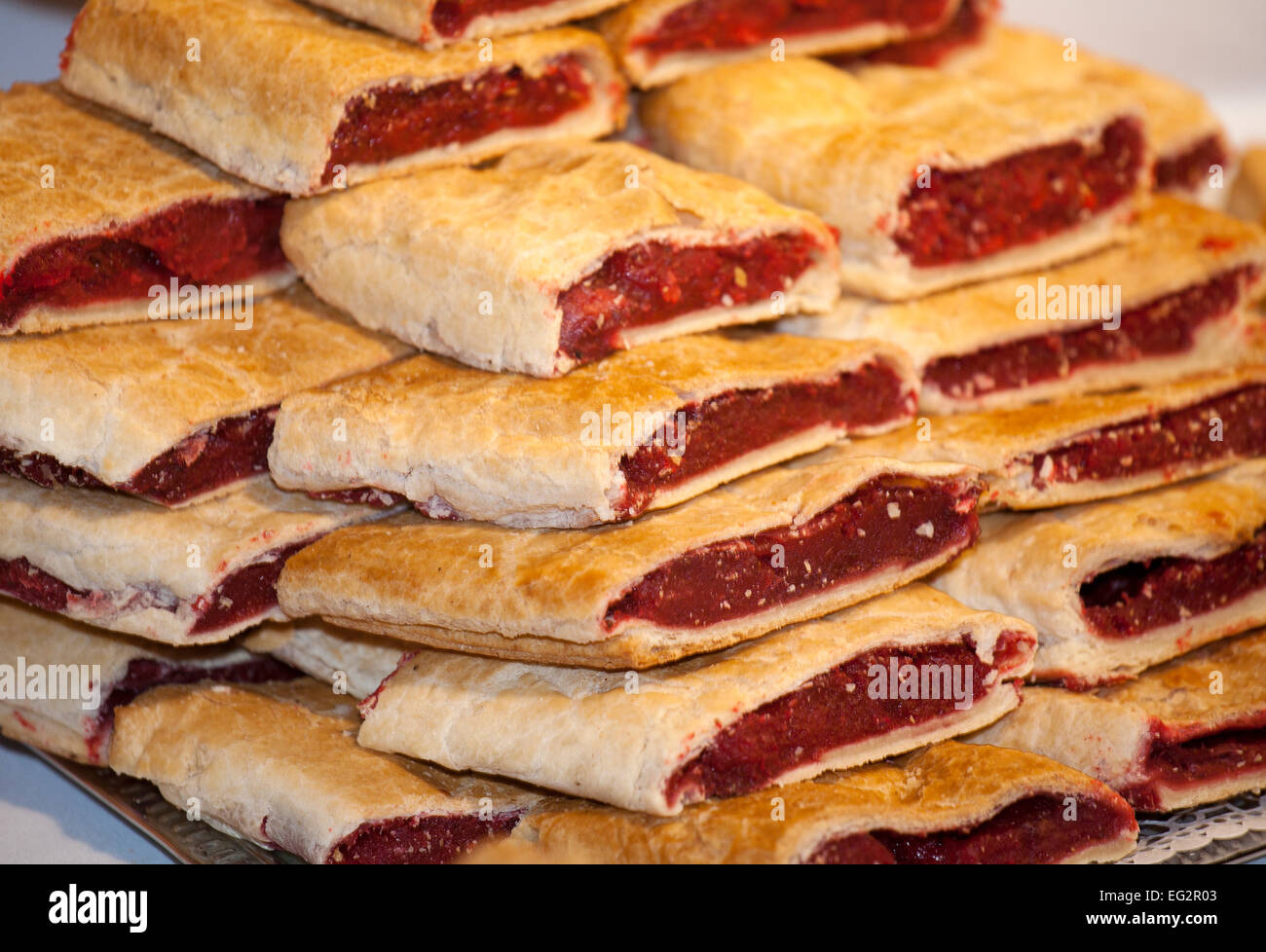 Group of cherry strudels with white dishes close up as a background ...