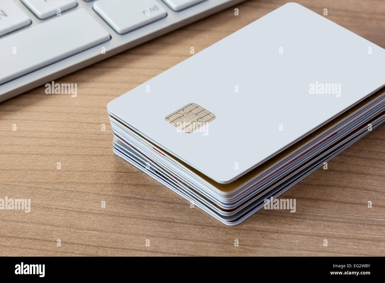 Batch of Credit or debit Cards on a wooden table with silver keyboard ...