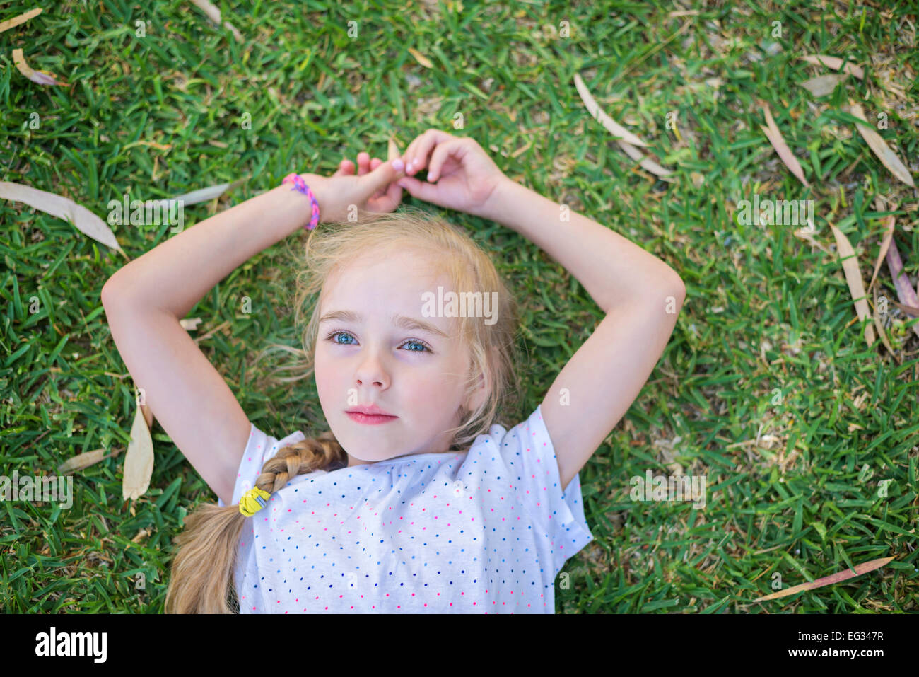 Caucasian little girl lay on grass Stock Photo - Alamy