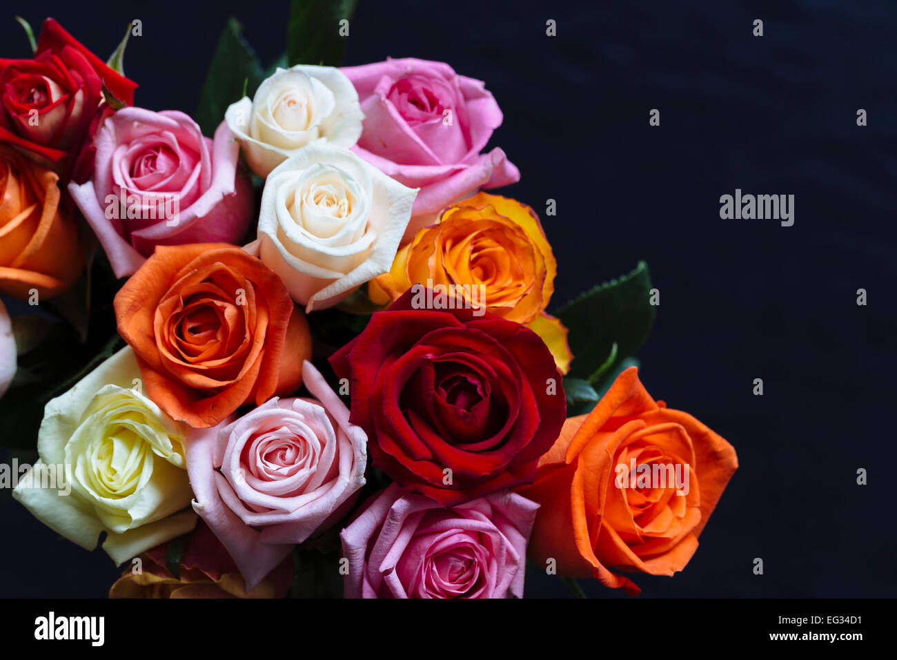 Bunch of colourful roses against dark surface Stock Photo - Alamy