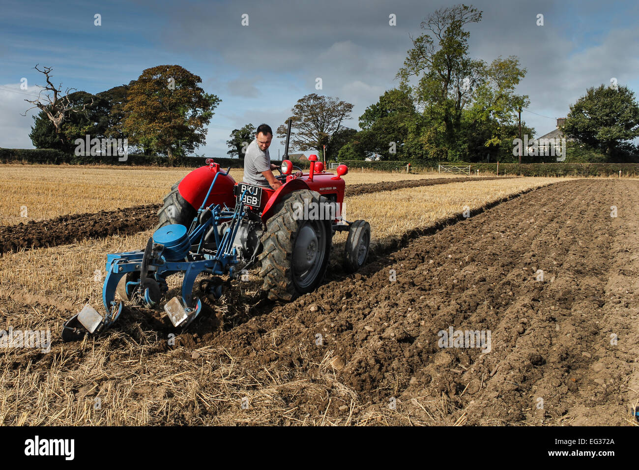 Tractor pulling plough to plough a field Stock Photo - Alamy