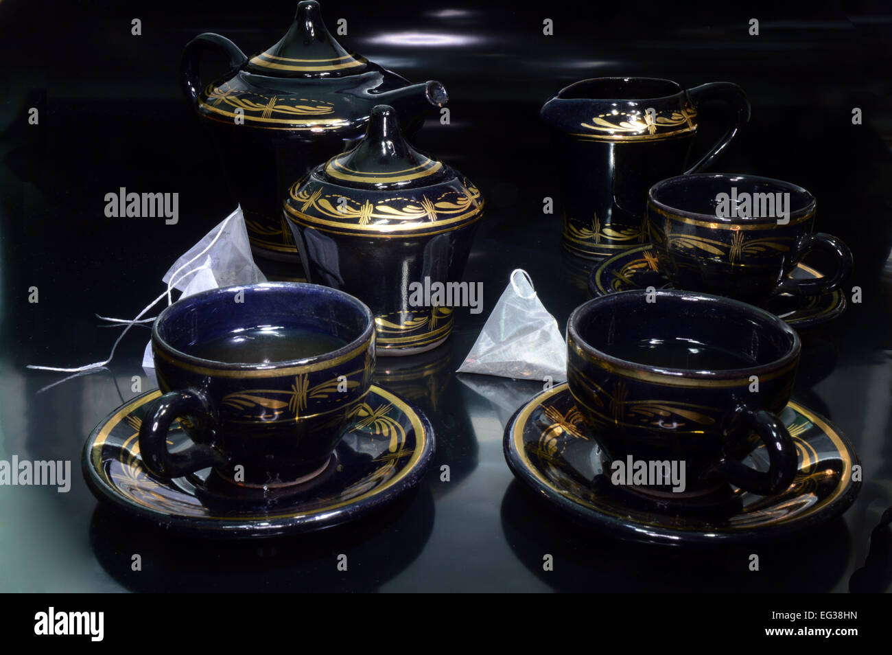 Tea party. Tea in cups, tea sets and tea bags on a black background ...