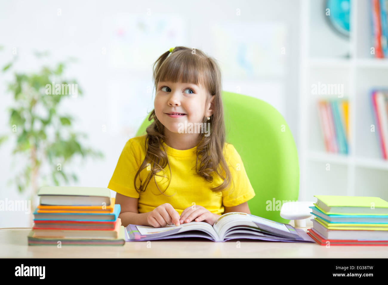 smiling child girl reading book at home Stock Photo - Alamy