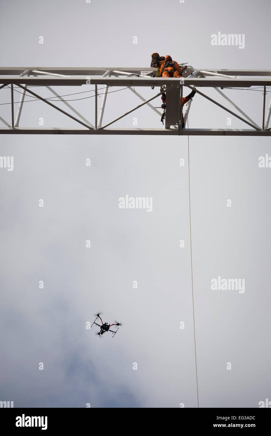 Workmen high on the jib of a crane that will construct the King's ...