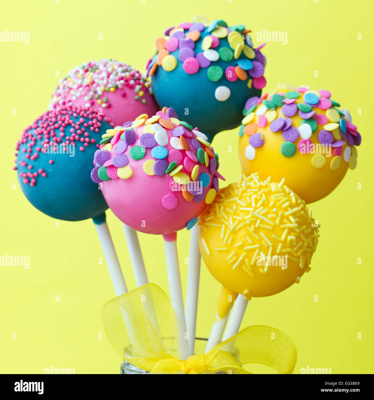 Colorful cake pops on a yellow background Stock Photo - Alamy