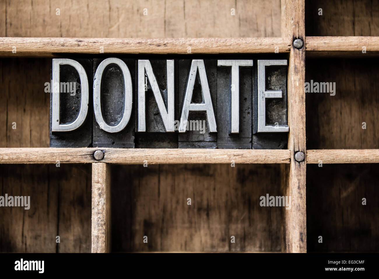 The word "DONATE" written in vintage metal letterpress type sitting in ...
