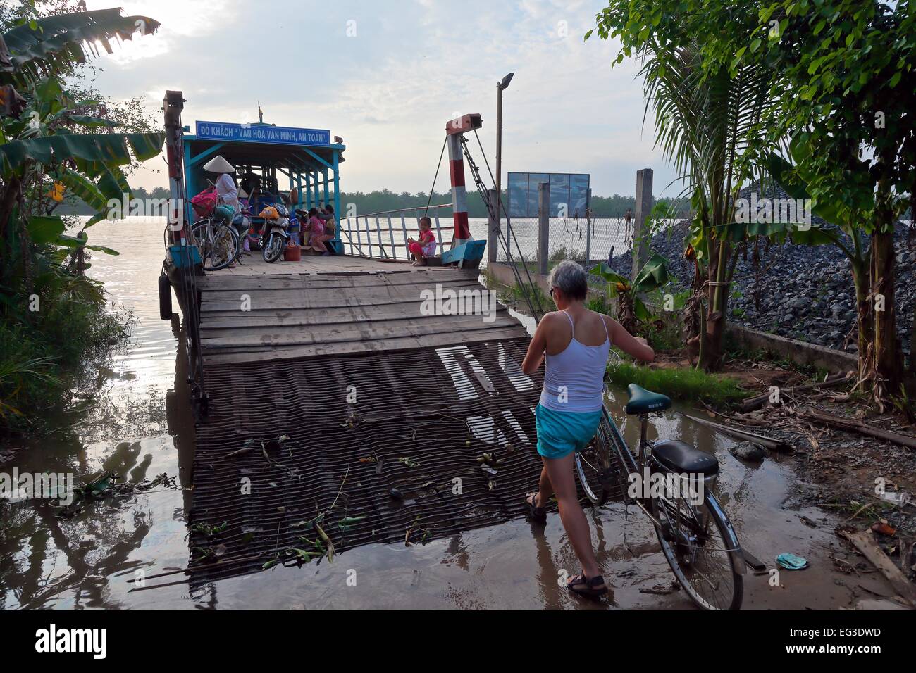 A european woman boards river ferry in Ben Tree during a cycle tour of ...