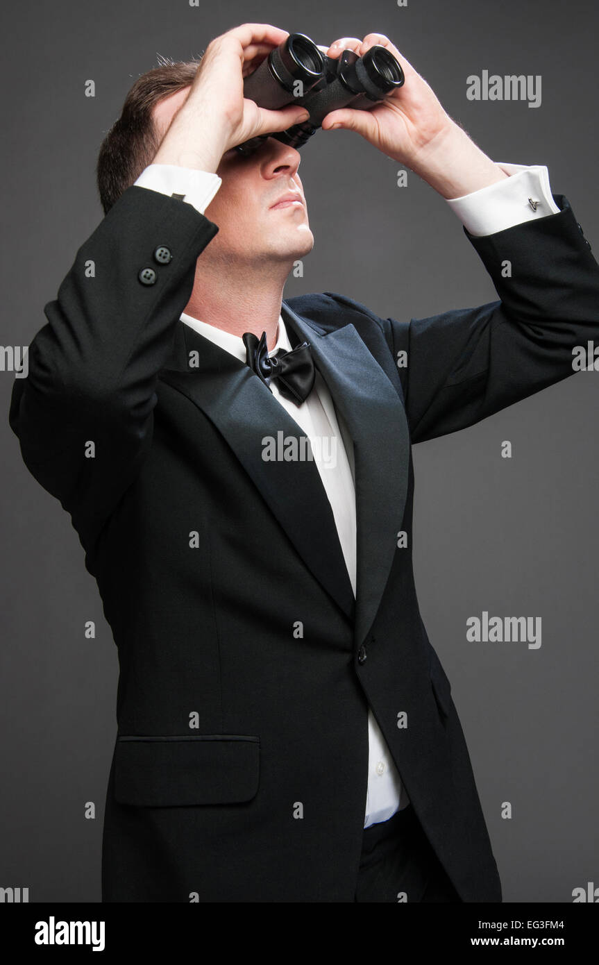 A man wearing a tuxedo looking through binoculars Stock Photo - Alamy