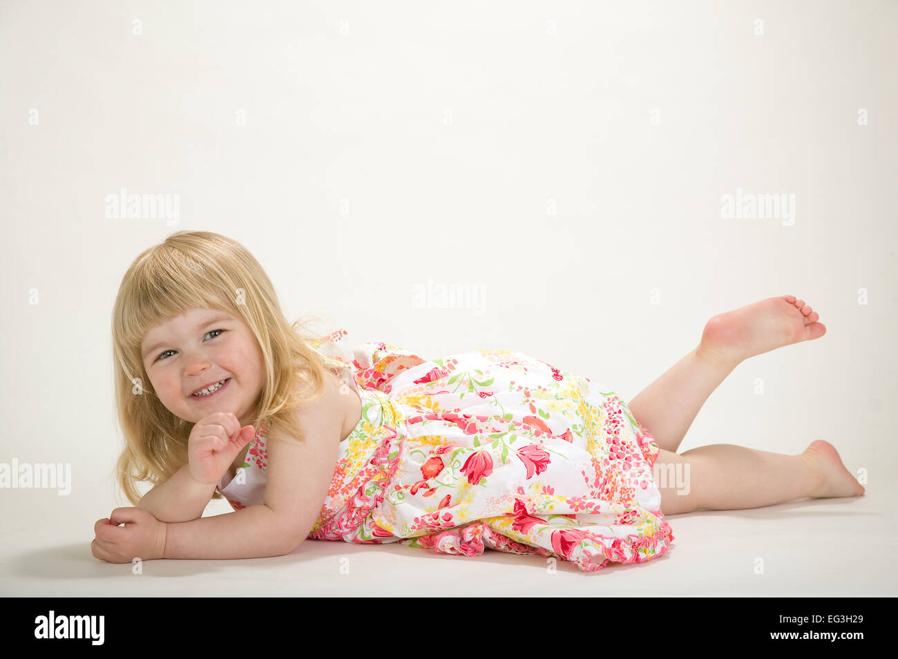 2.5 years old toddler girl striking a pose lying down Stock Photo - Alamy