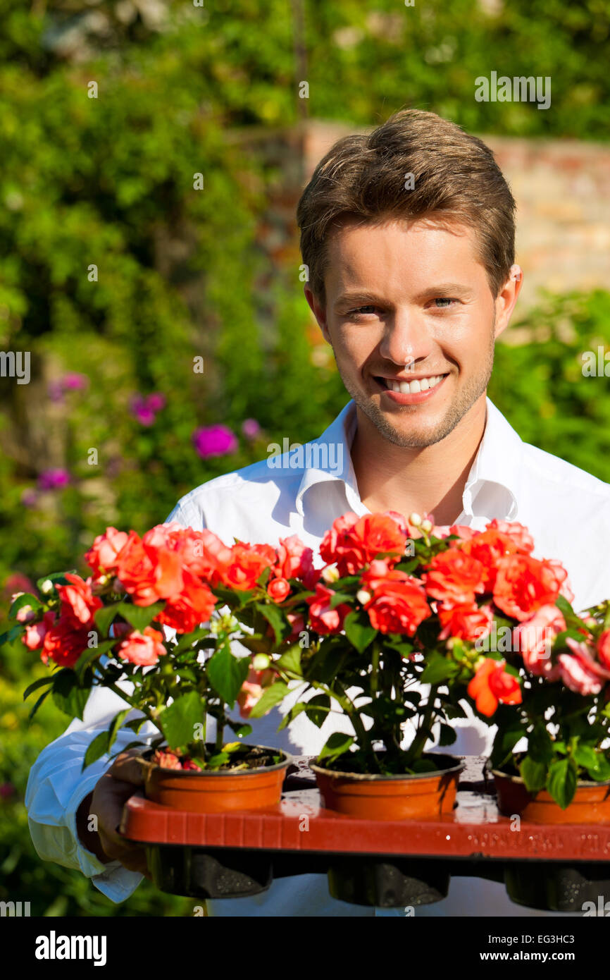 Gardening in summer - man with flowers in his garden Stock Photo - Alamy