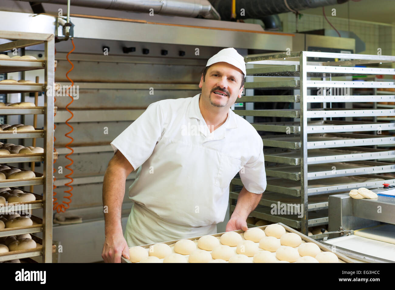 Male baker baking fresh bread rolls in the bakehouse Stock Photo - Alamy