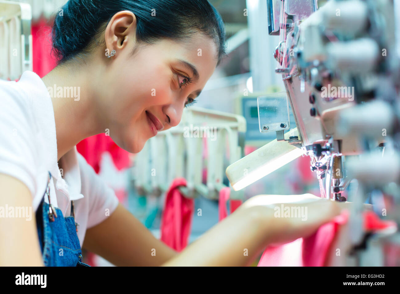 Asian Seamstress or worker in an Asian textile factory sewing with a ...