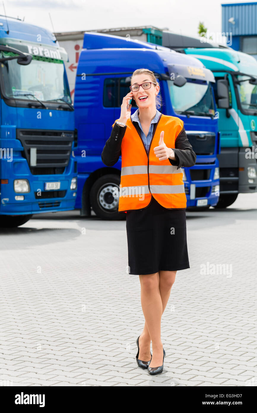 Logistics - female forwarder or supervisor with mobile phone, in front ...