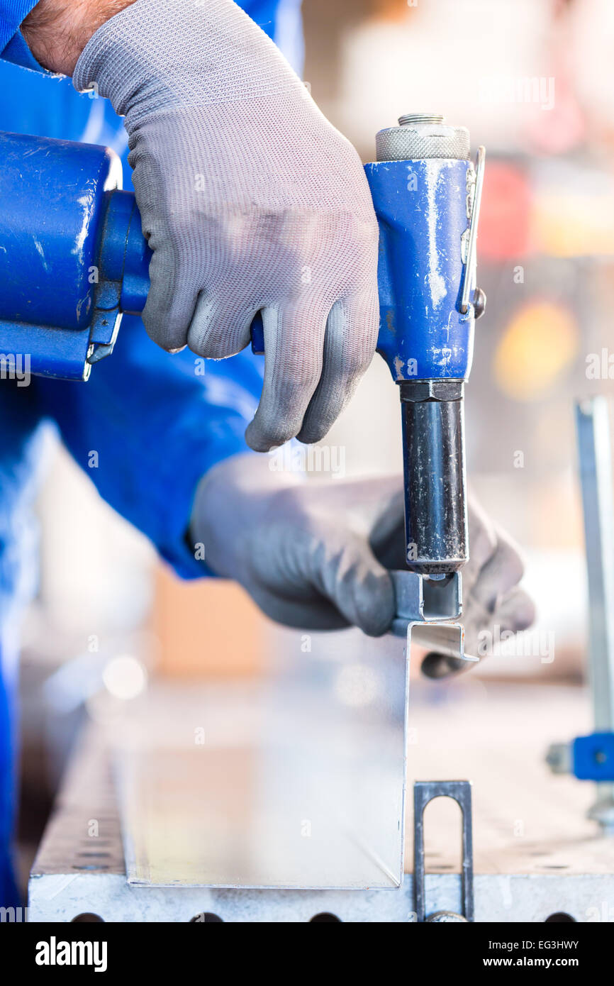 Craftsman rivet metal with air compressed pistol in workshop Stock ...