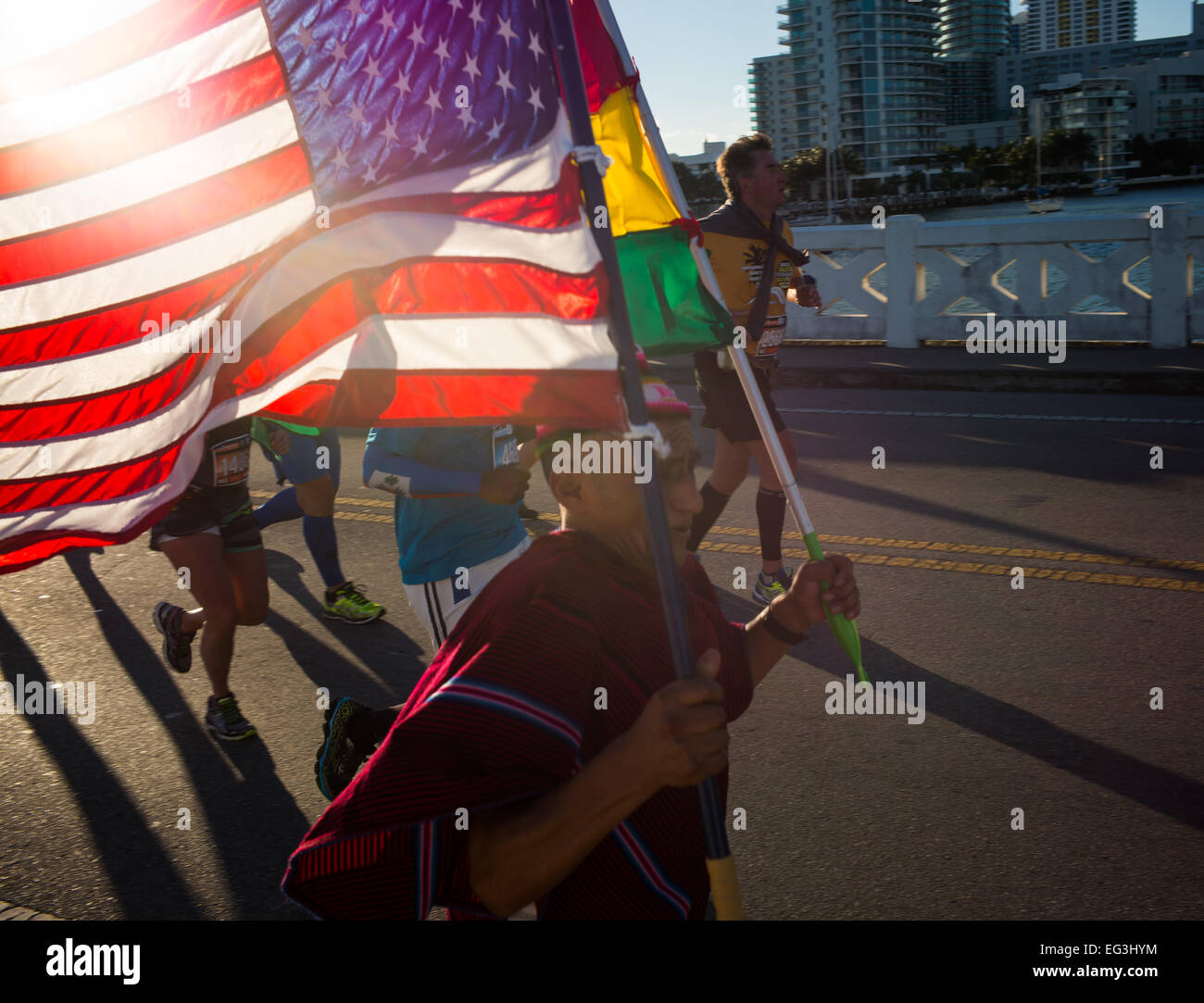A runner carries a U.S. and Bolivian flag as he competes in the Miami ...