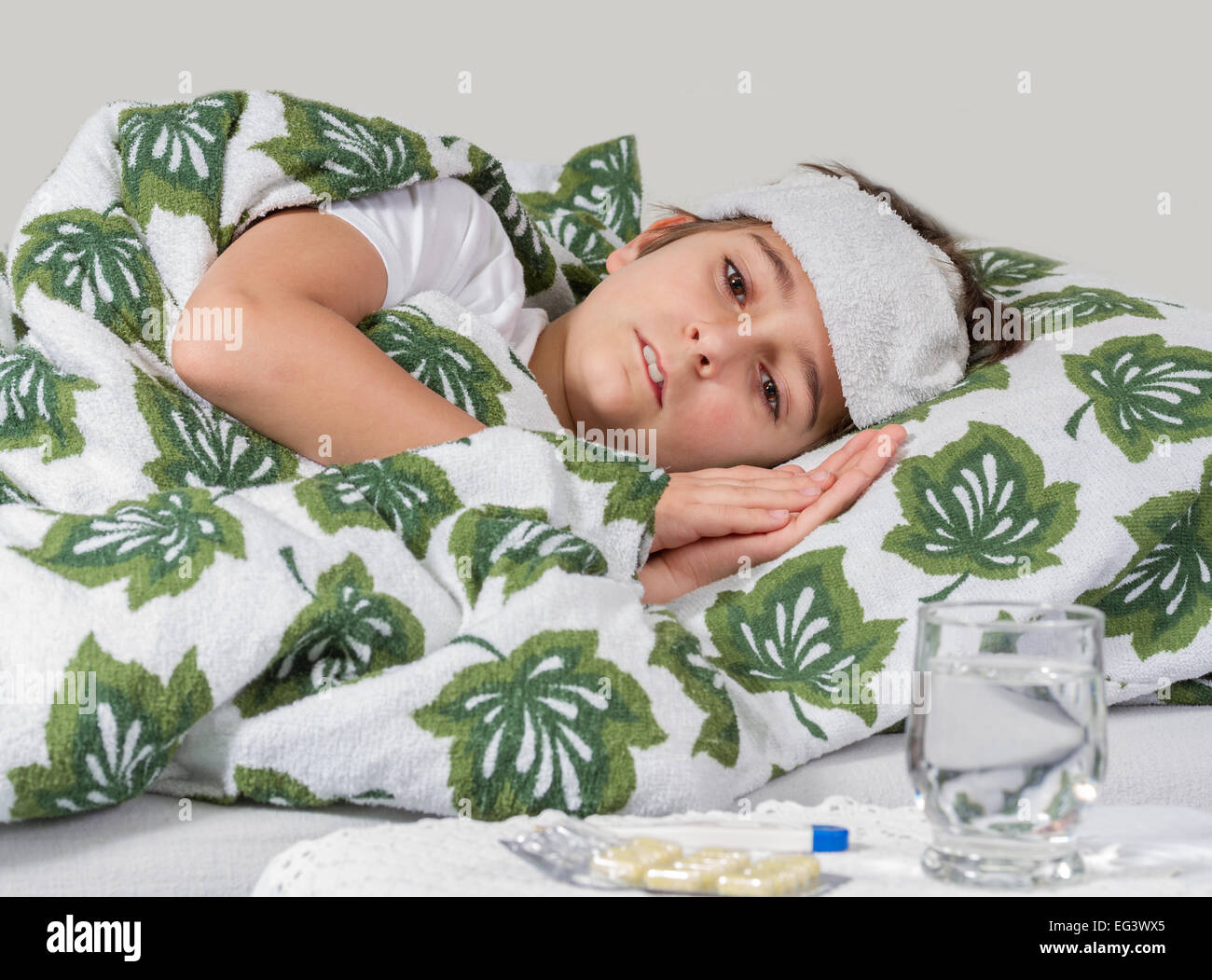 Sick boy lying in bed with high fever Stock Photo - Alamy