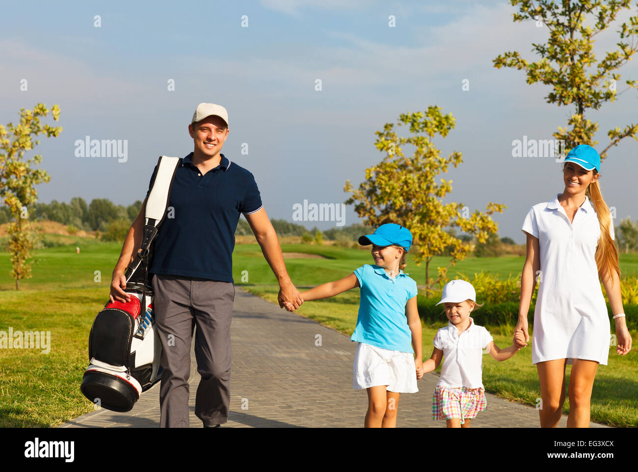 Family of golf players walking at the course Stock Photo - Alamy