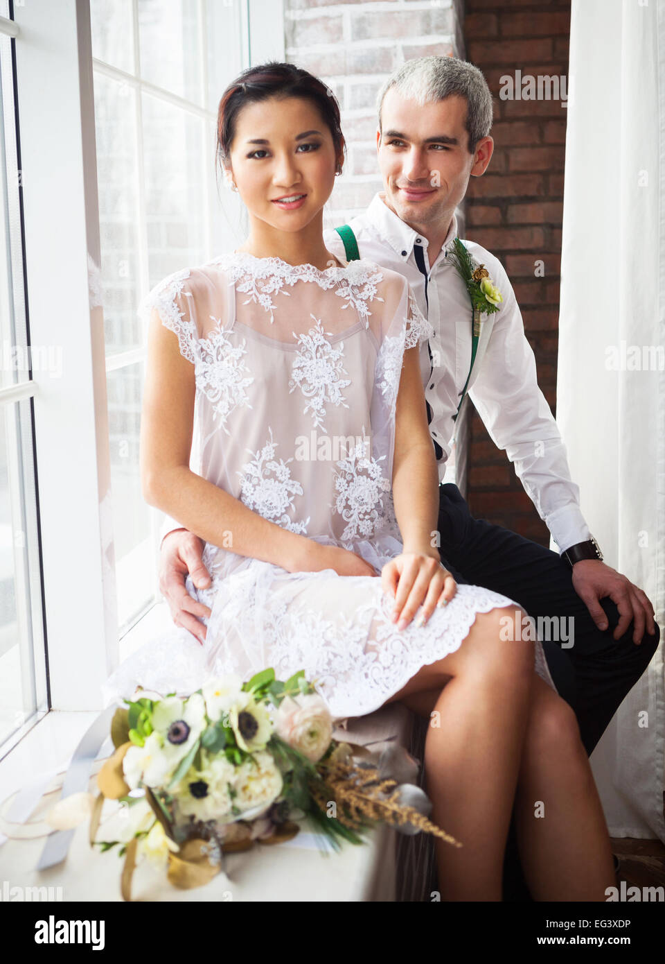 Cheerful married couple sitting near the window Stock Photo - Alamy