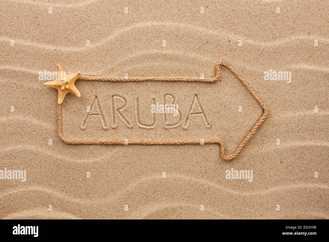 Arrow made of rope and sea shells with the word Aruba on the sand, as ...