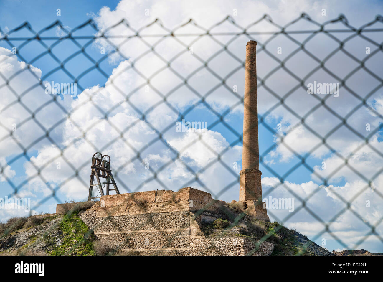 Old industrial factory ruin photographed through its surrounding fence ...