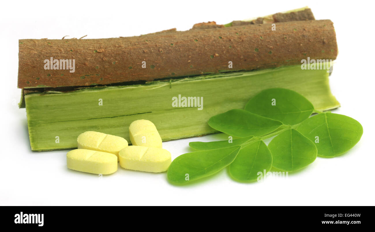 Moringa leaves and bark with pills over white background Stock Photo ...