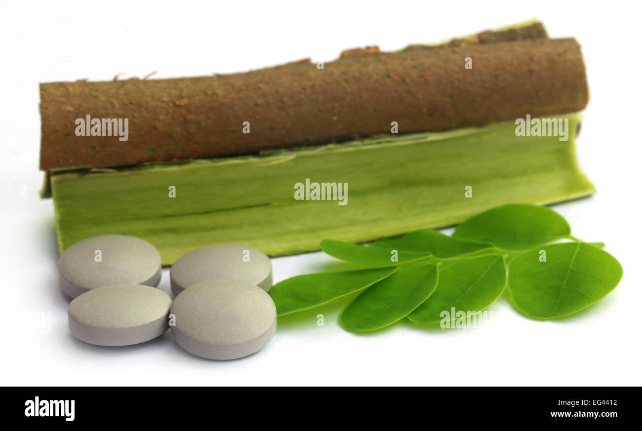 Moringa leaves and bark with pills over white background Stock Photo ...