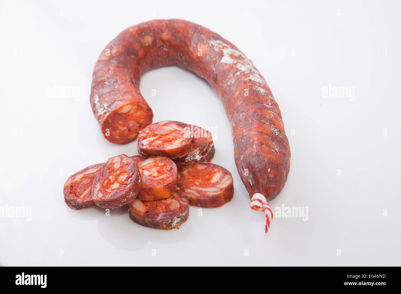 Red iberian chorizo with some cut pieces. Isolated over white ...