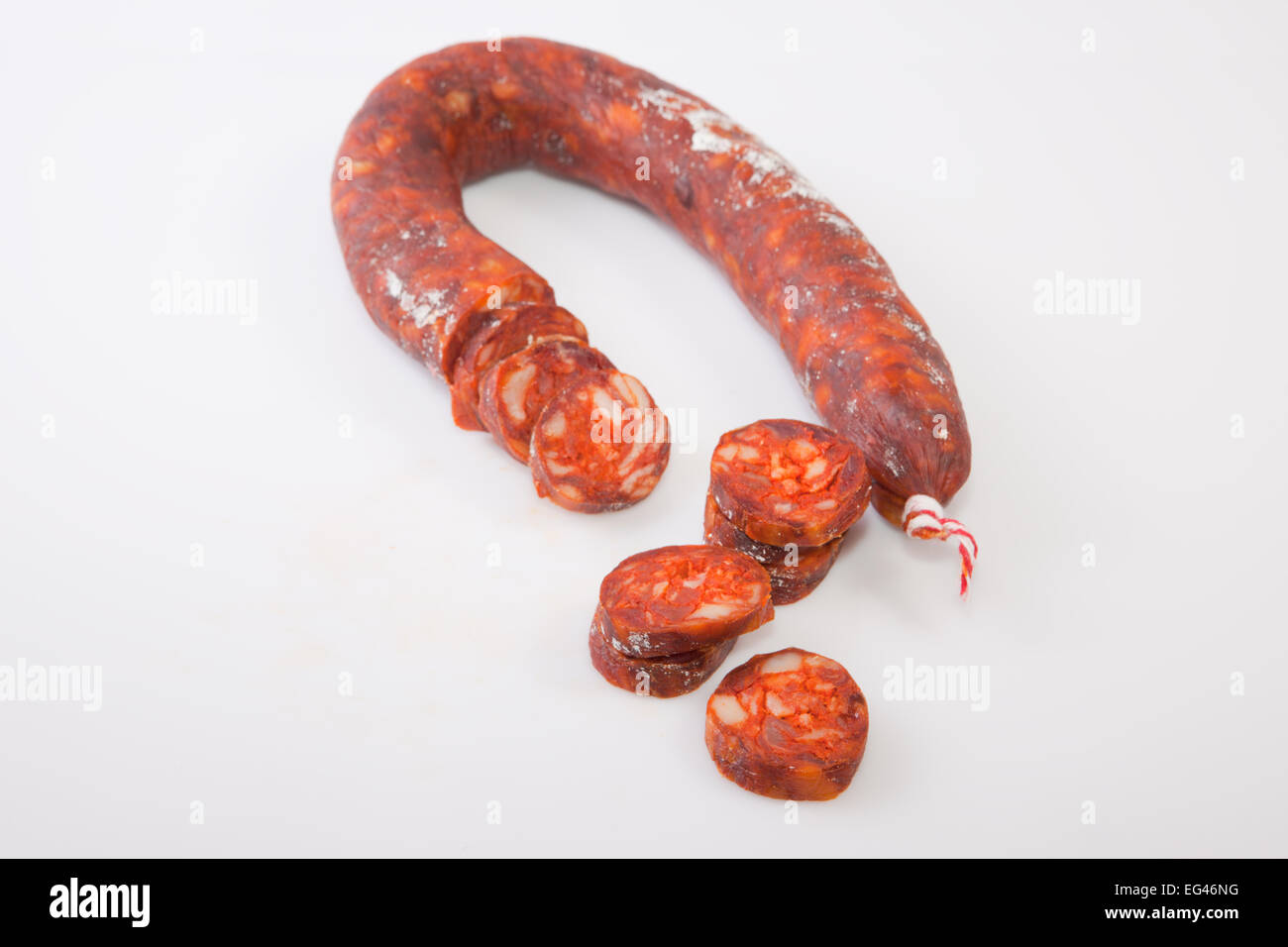 Red iberian chorizo with some cut pieces. Isolated over white ...