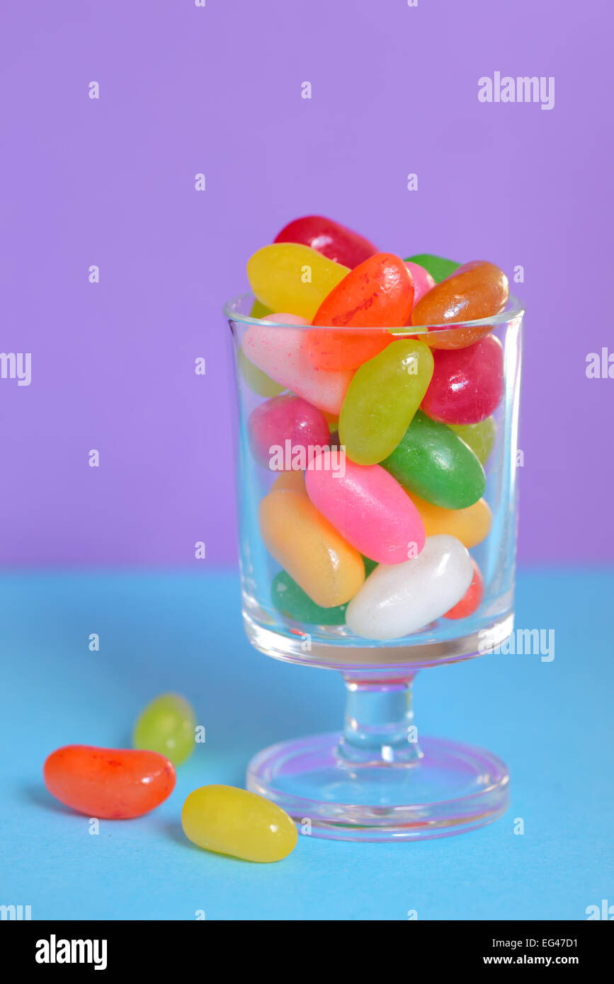color Jelly Beans in glass on lila background Stock Photo - Alamy