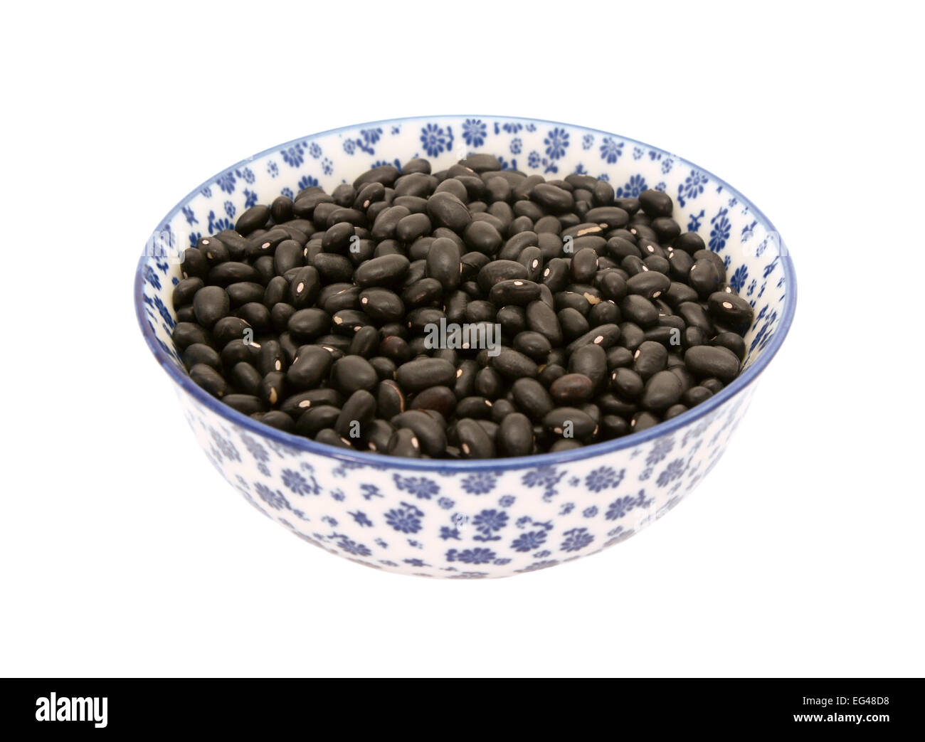 Black turtle beans in a blue and white porcelain bowl with a floral ...