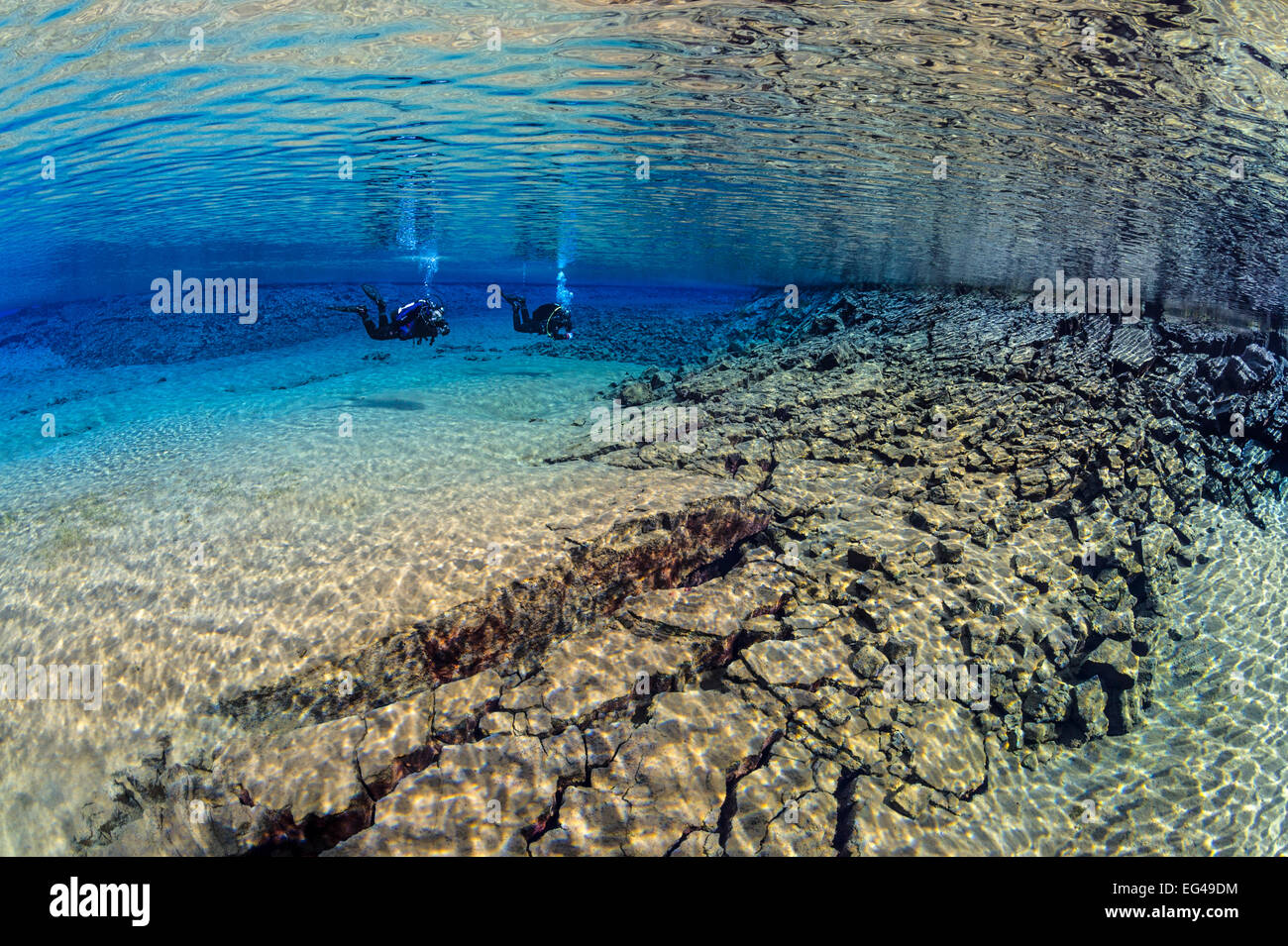 Pair divers swimming in the blue lagoon at Silfraa fractured rocks in ...