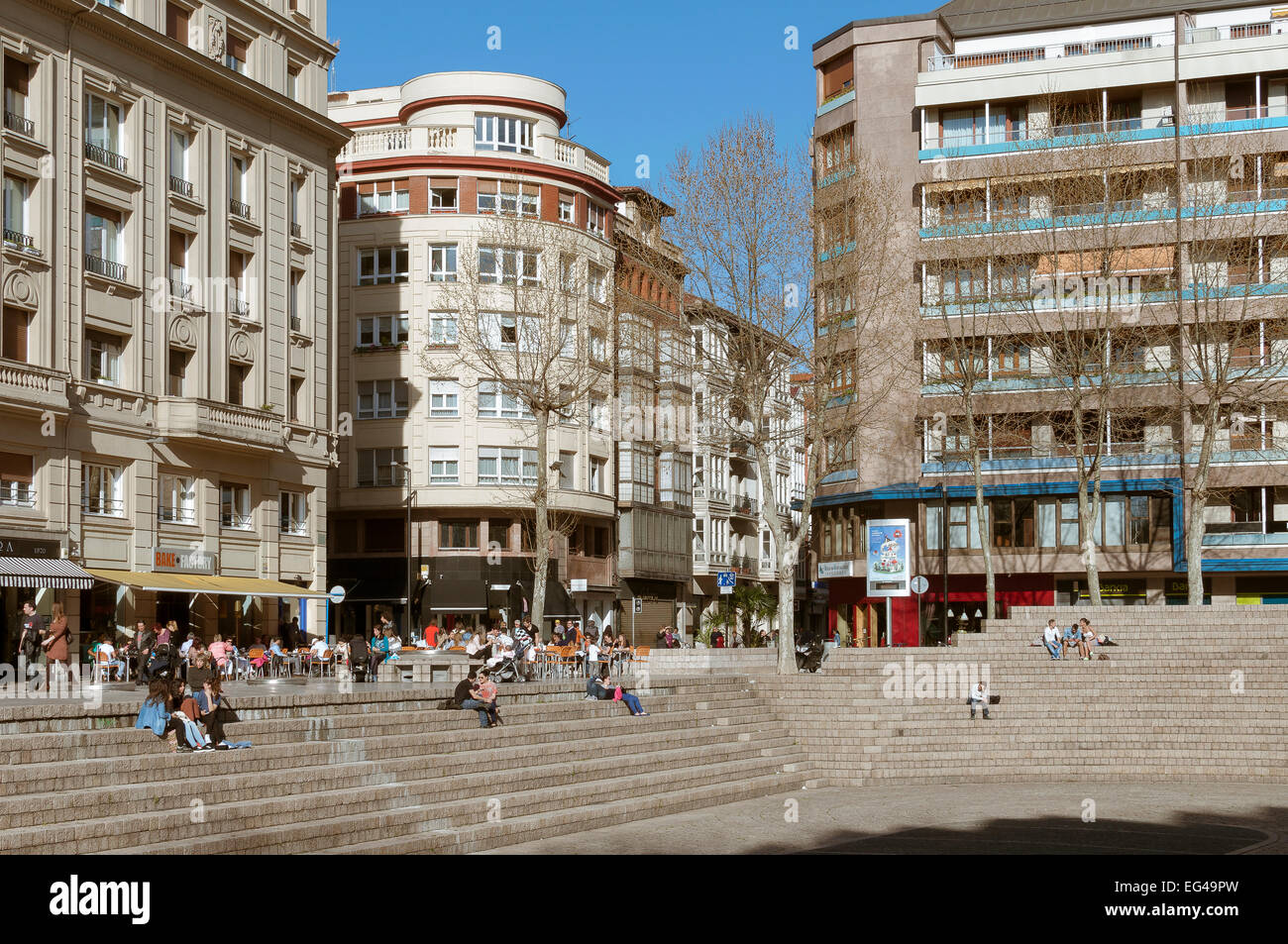 People sunbathing on the steps of a square of a neighborhood of Vitoria ...