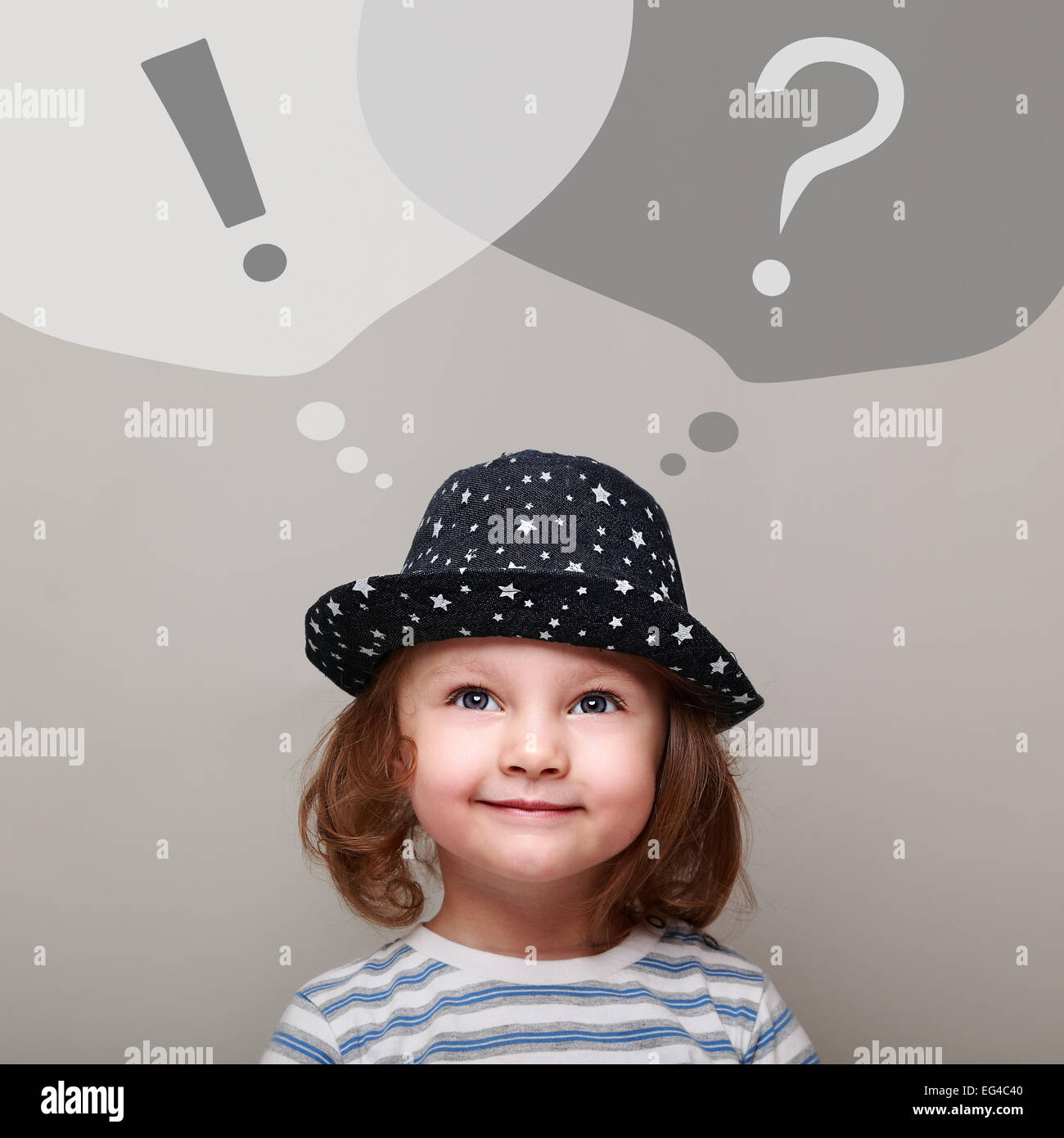 Thinking happy kid girl looking up on question and exclamation signs on ...