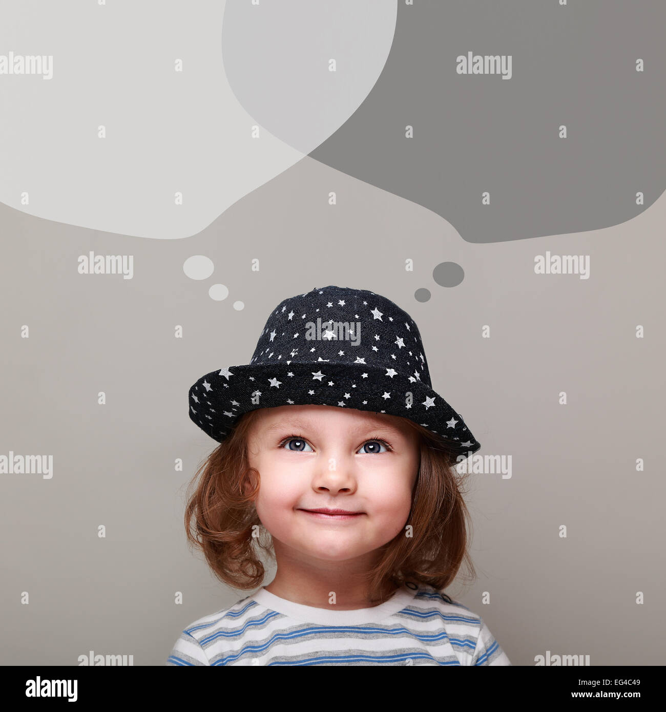Happy kid thinking and looking up on chat bubbles above on grey ...