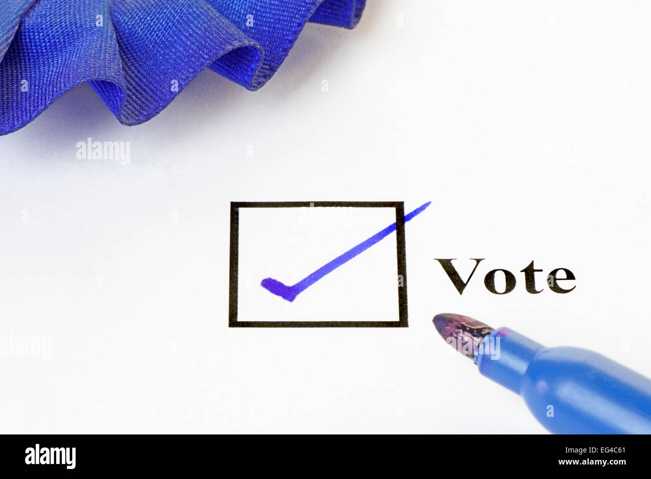 Vote marked with a blue tick. With pen and rosette Stock Photo - Alamy