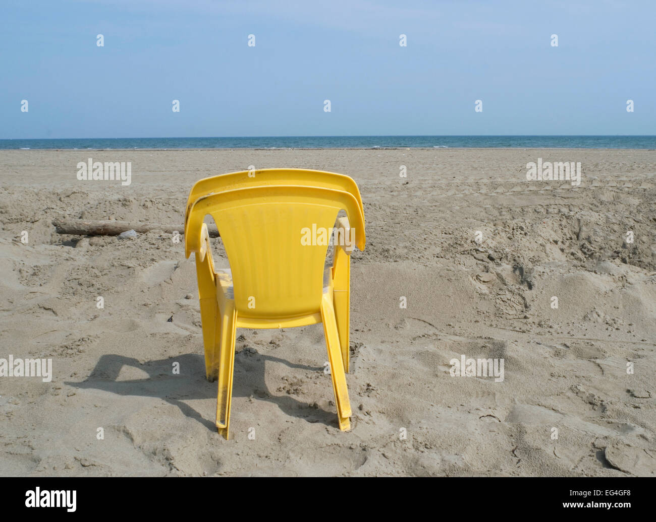 piled chairs abandoned on the beach Stock Photo - Alamy