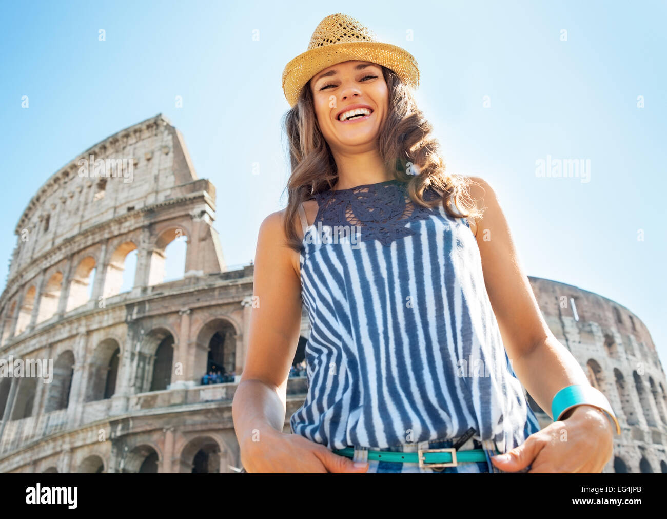 Portrait of happy young woman in front of colosseum in rome, italy ...