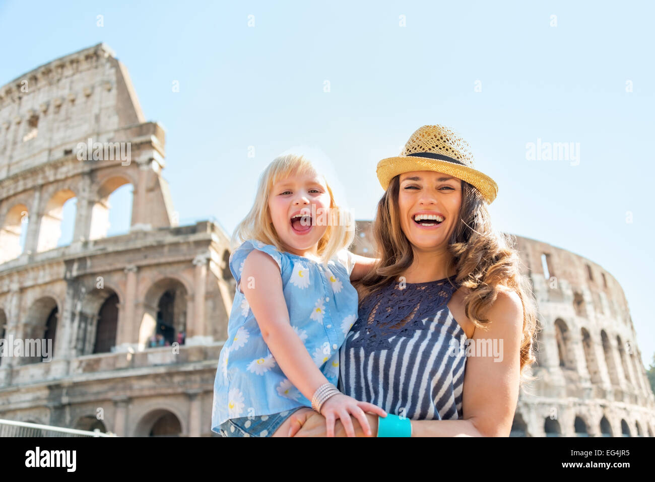 Portrait of happy mother and baby girl in front of colosseum in rome ...