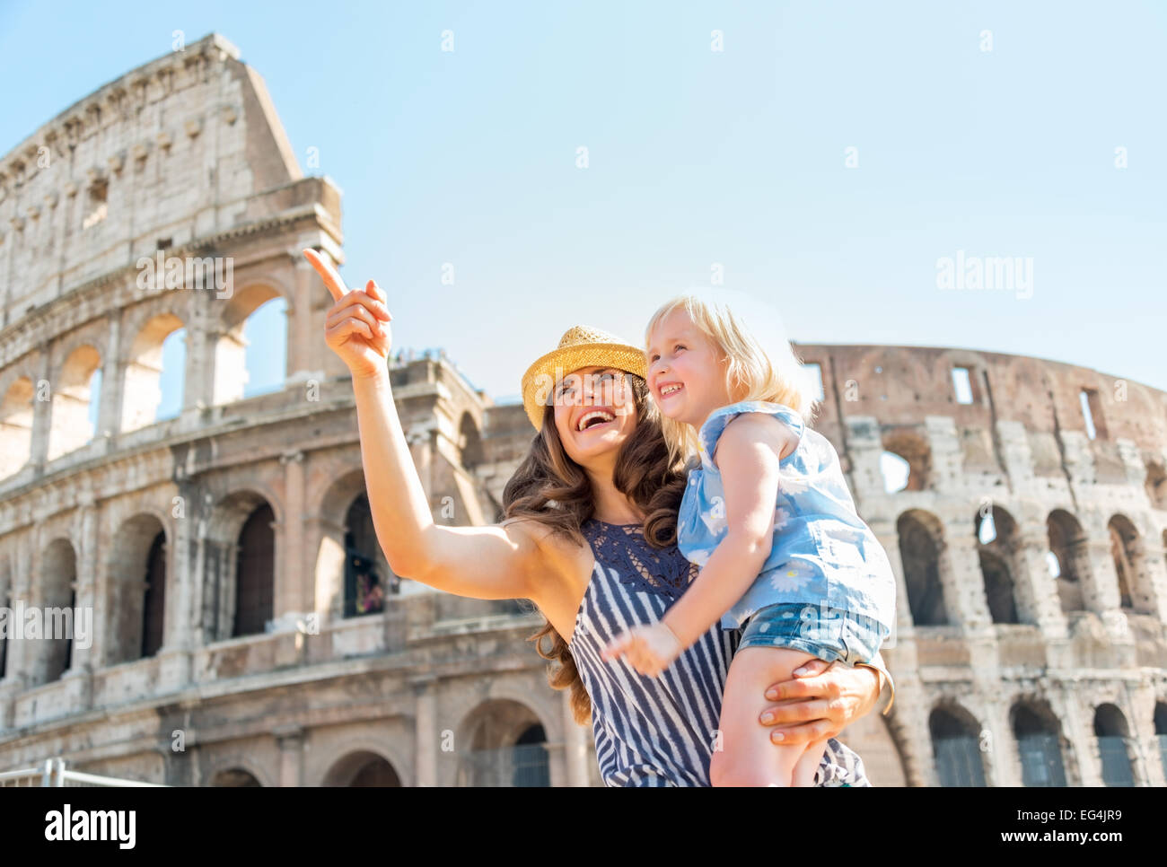 Happy mother and baby girl sightseeing near colosseum in rome, italy ...