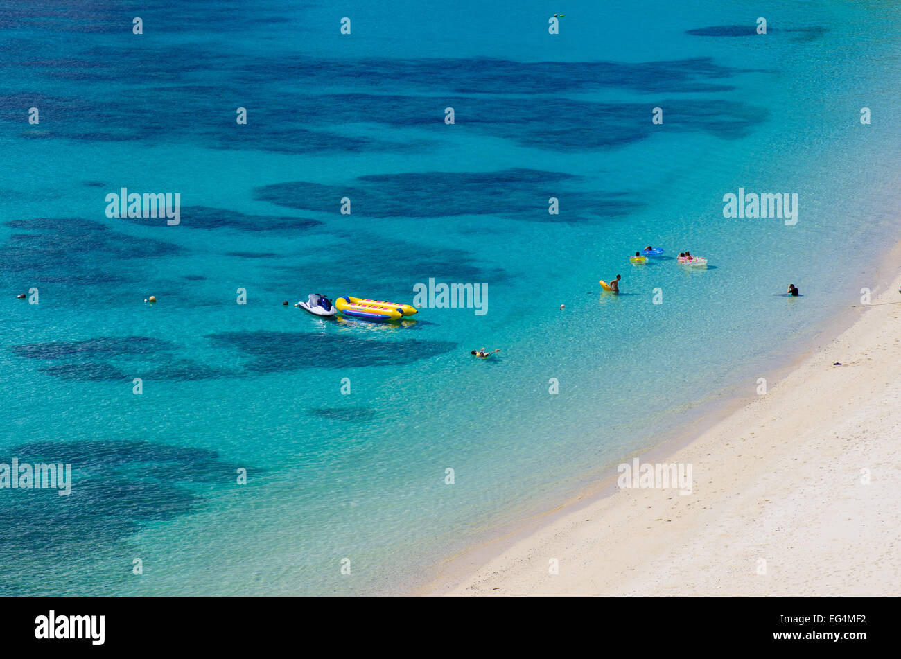 The famous "Kerama Blue" of Aharen Beach with people snorkeling among ...