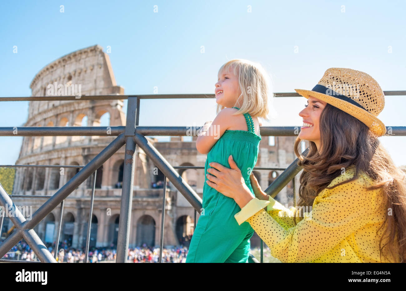 Mother and baby girl looking on copy space in front of colosseum in ...