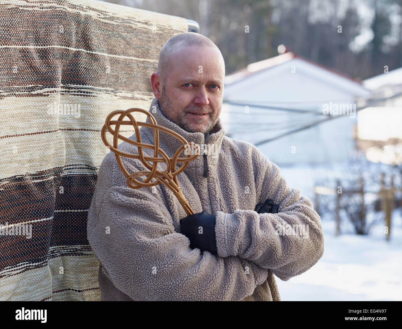Homeworks, a man and the carpet beater Stock Photo - Alamy