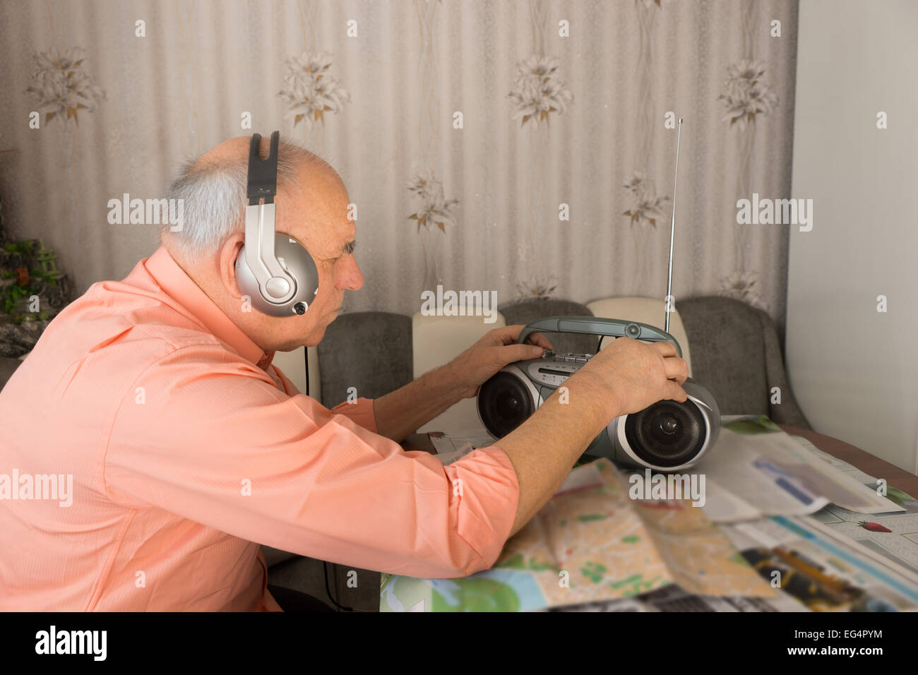 Sitting Elderly Listening at the Radio with Headset at the Table Inside ...