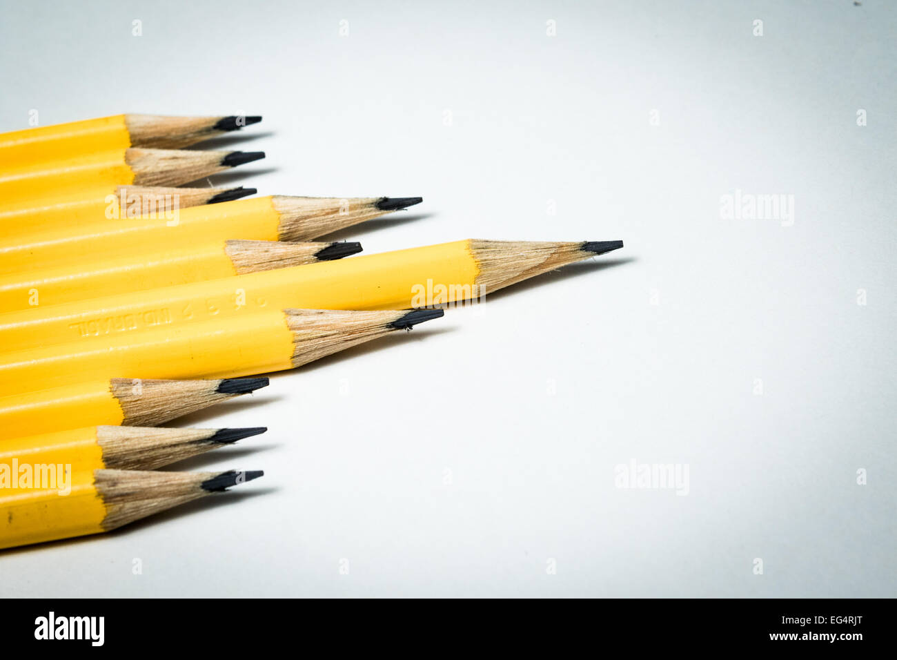 A group of yellow pencils aiming to one direction as a conceptual image ...