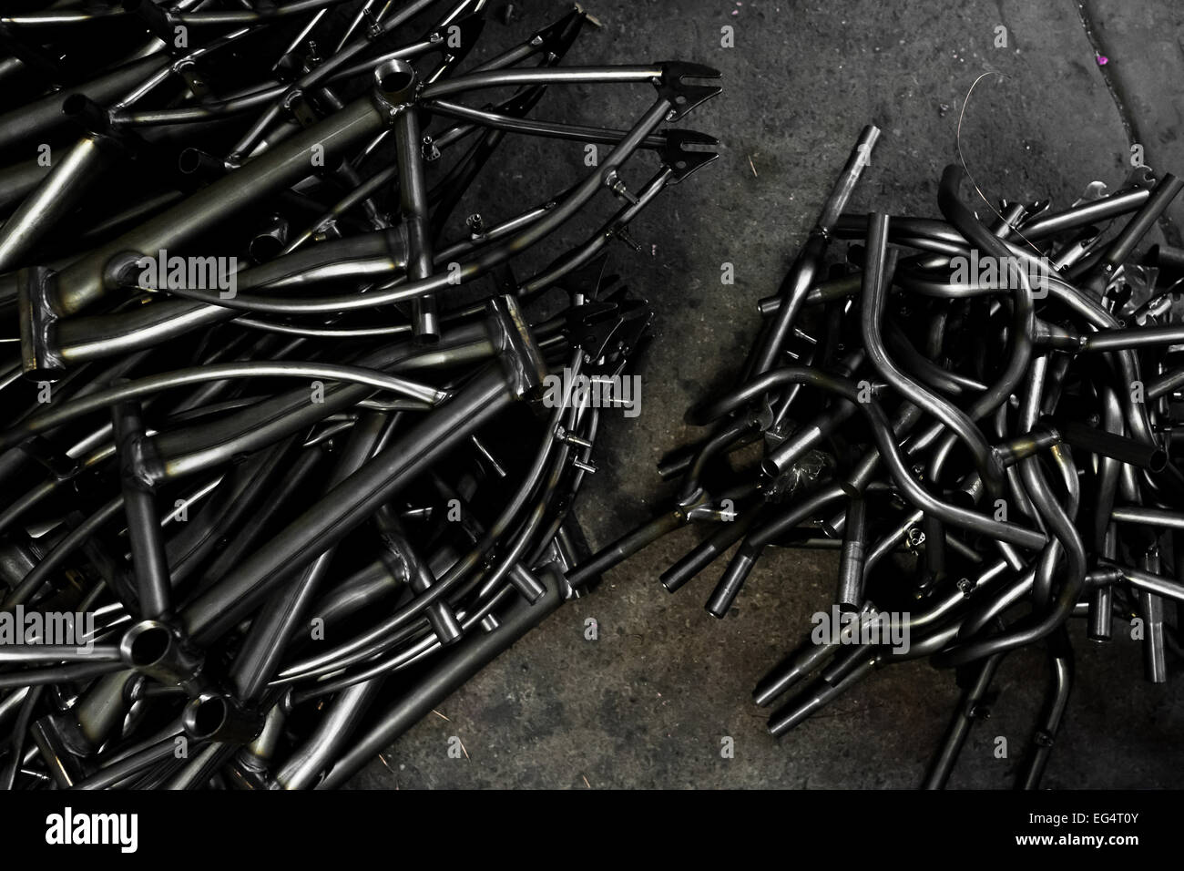 Recently welded bike frames are seen piled up in a small scale bicycle ...