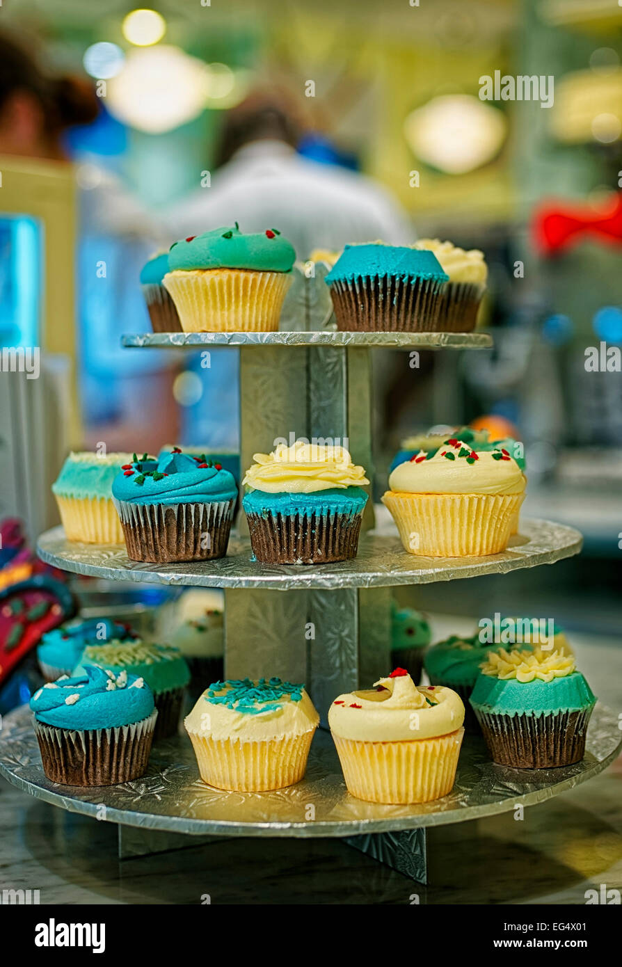 Assorted colored cupcakes on the bakery storefront with blurred ...