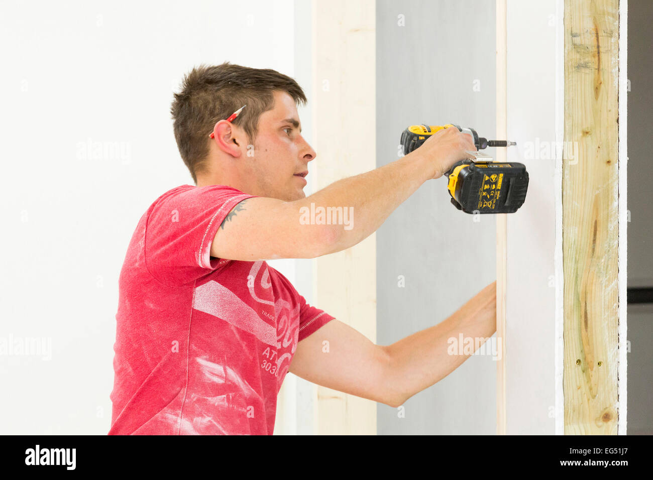 construction worker using a cordless drill to construct a drywall Stock ...