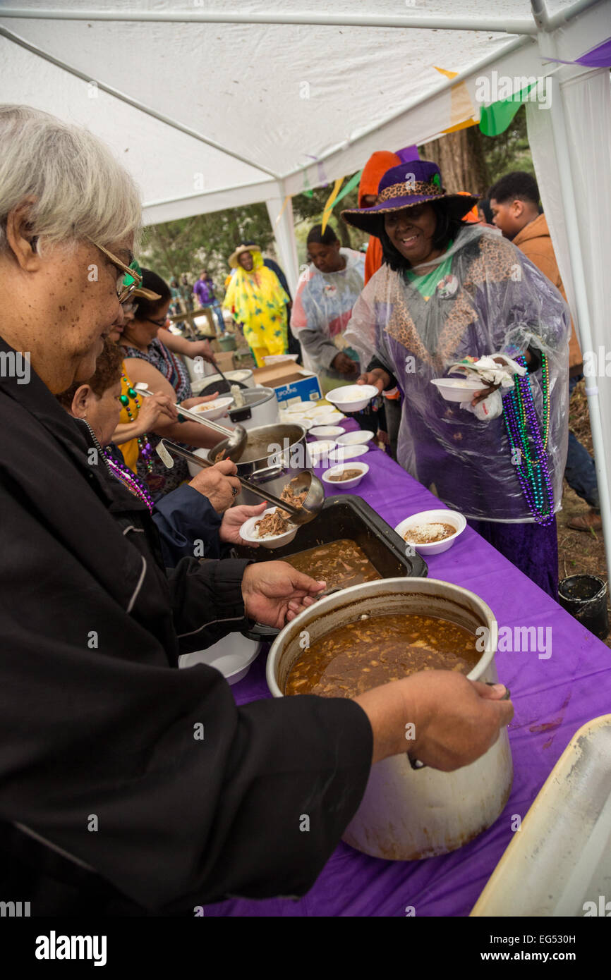 A family dishes out homemade gumbo for revelers during a stop at the ...