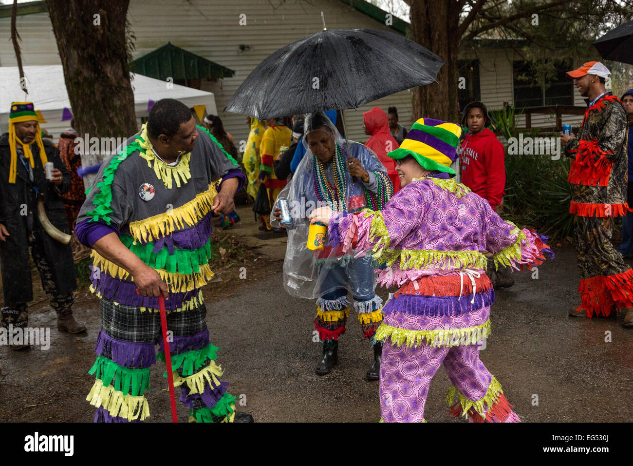 Costumed revelers dance in the rain during a stop at the Creole Courir ...