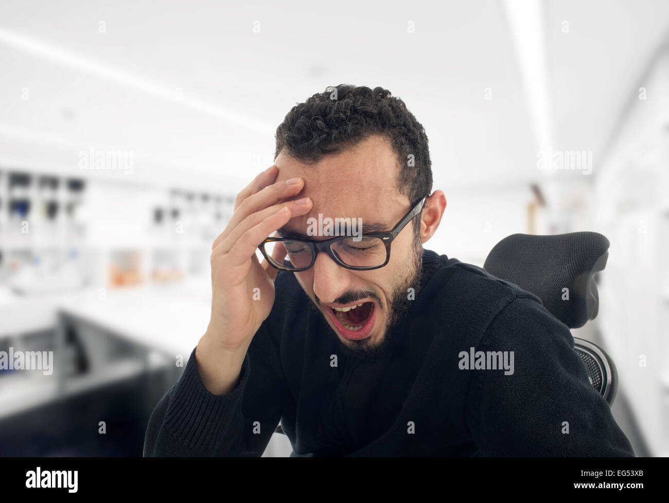 young businessman yawning at work in office Stock Photo - Alamy